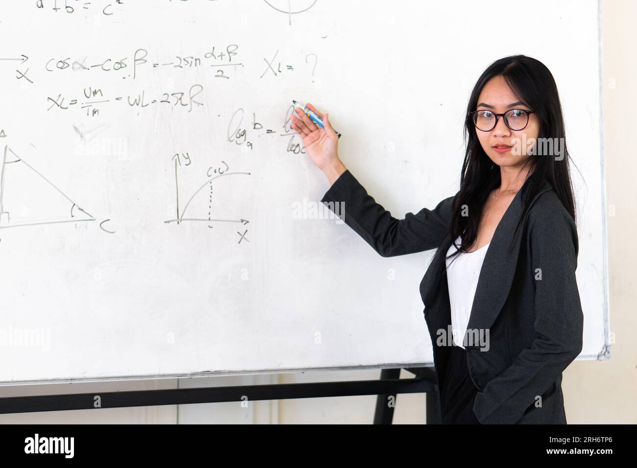 asian teacher write on white board. Woman writing on white board wall ...