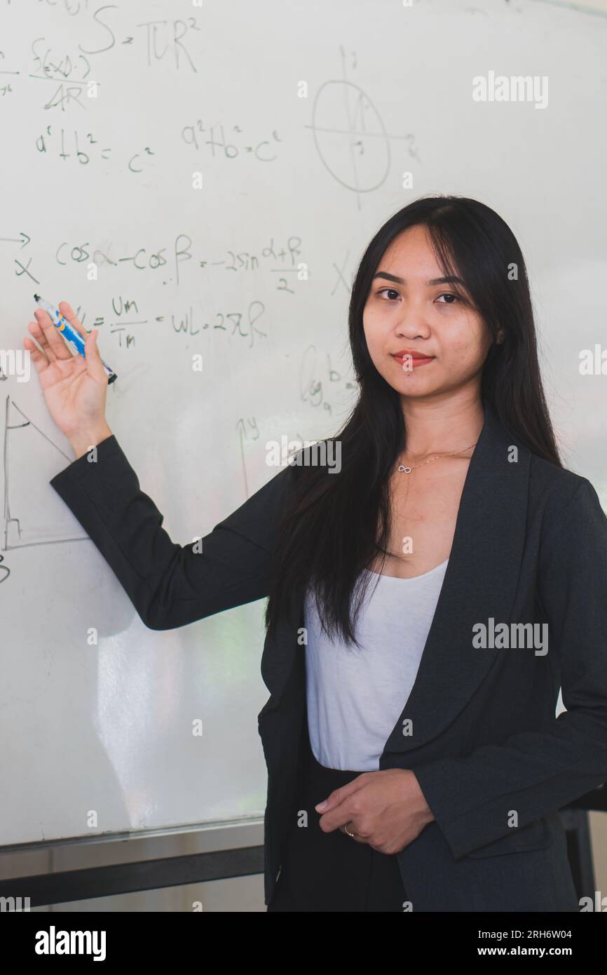 asian teacher write on white board. Woman writing on white board wall ...