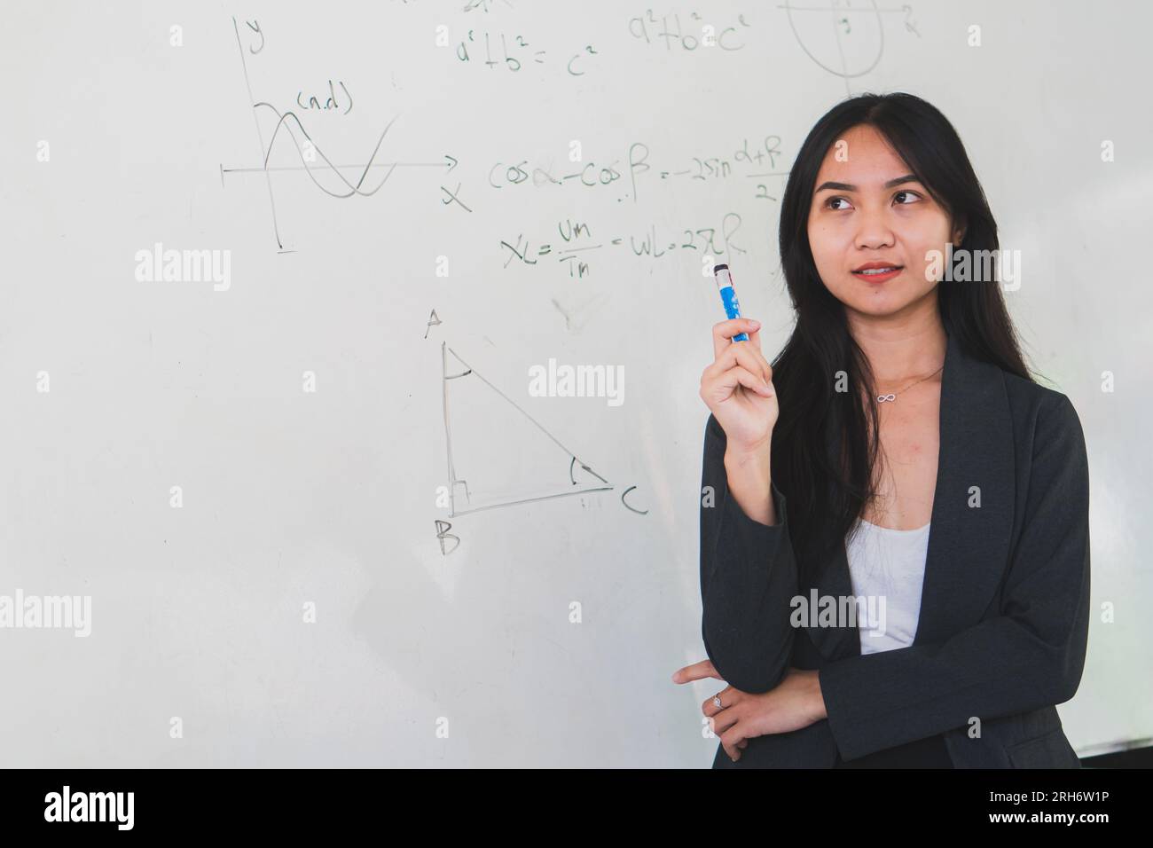 asian teacher write on white board. Woman writing on white board wall ...