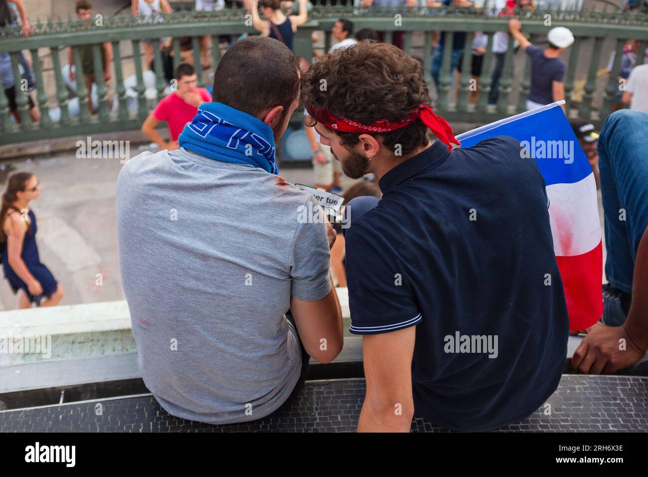 Paris, France, 2018. A couple of young men huddled together on the July ...