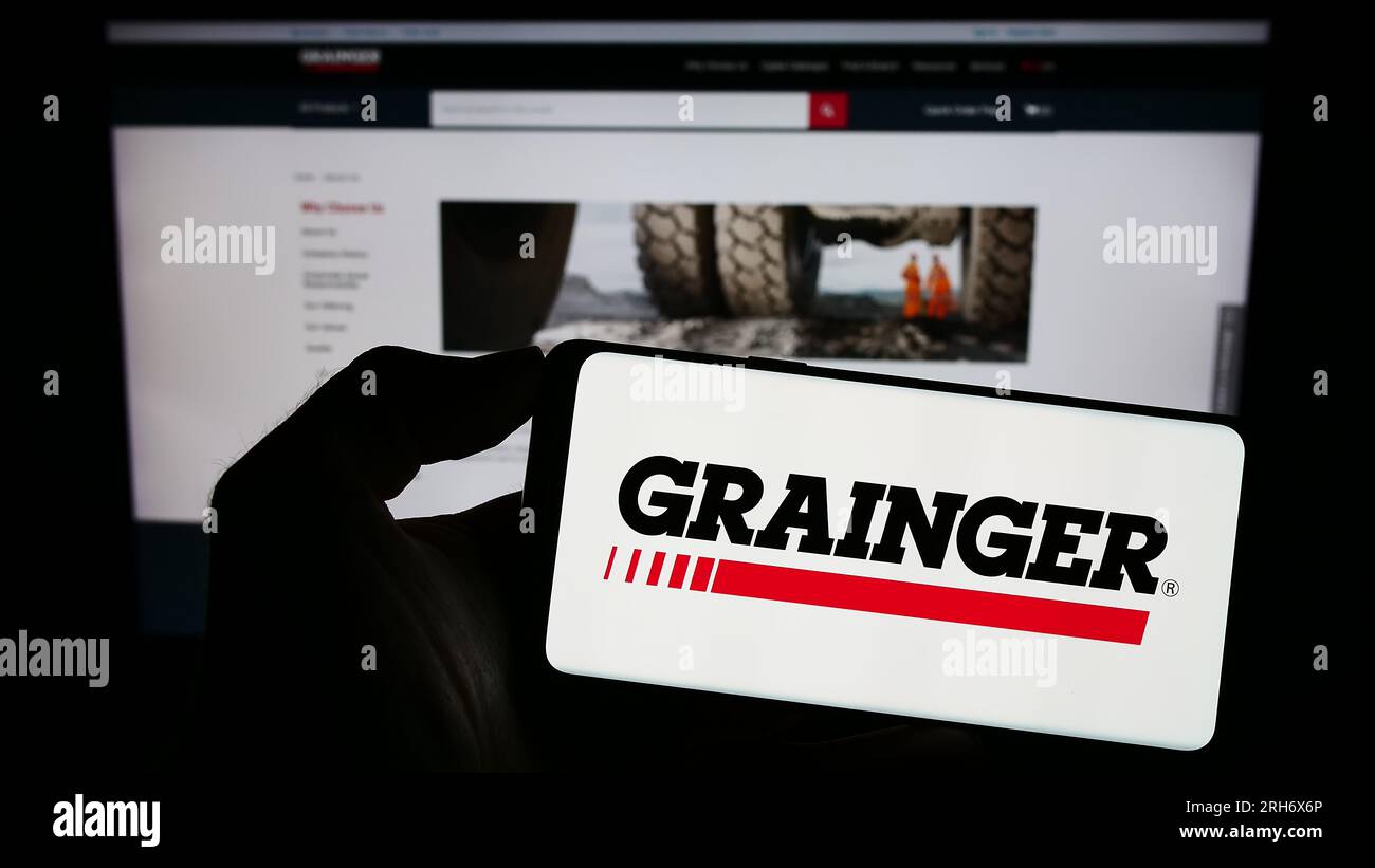 Person holding smartphone with logo of US industrial supply company W.W ...