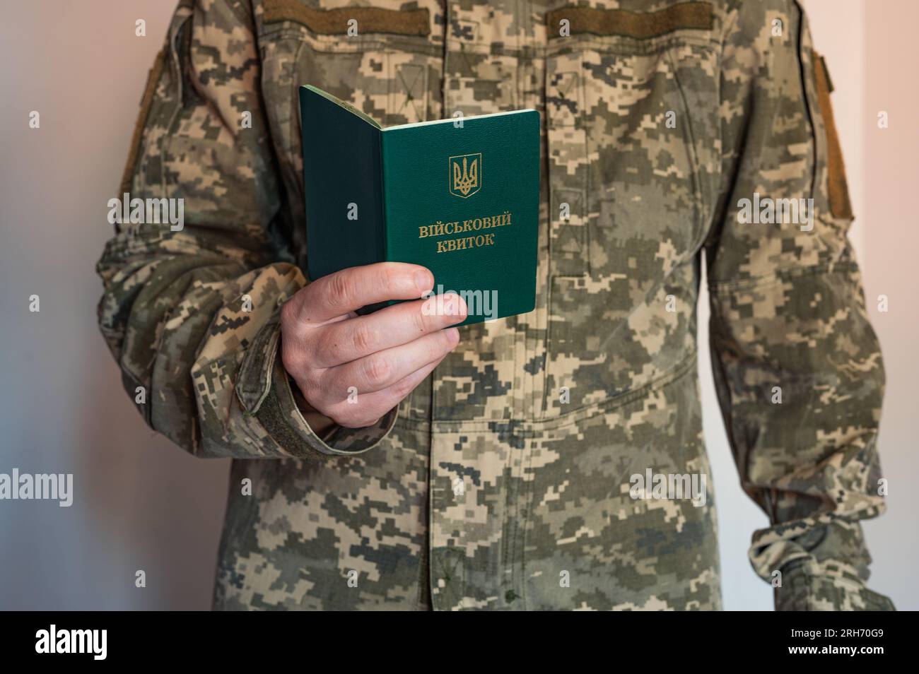 Soldier in tactic suit holds open military id in hand. Ukrainian pixel ...