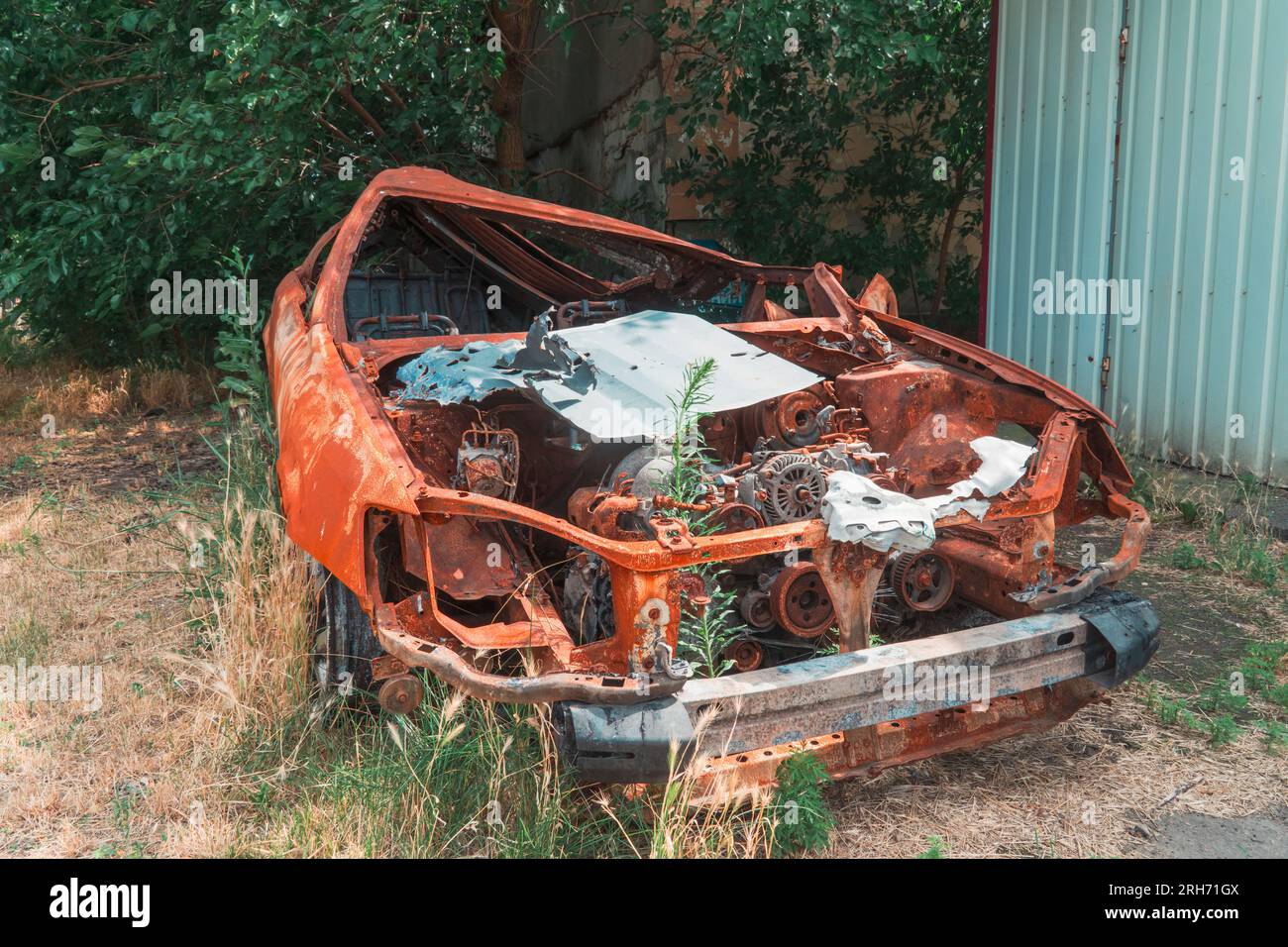 On the side of the road is a wrecked, burned-out civilian car. War in ...