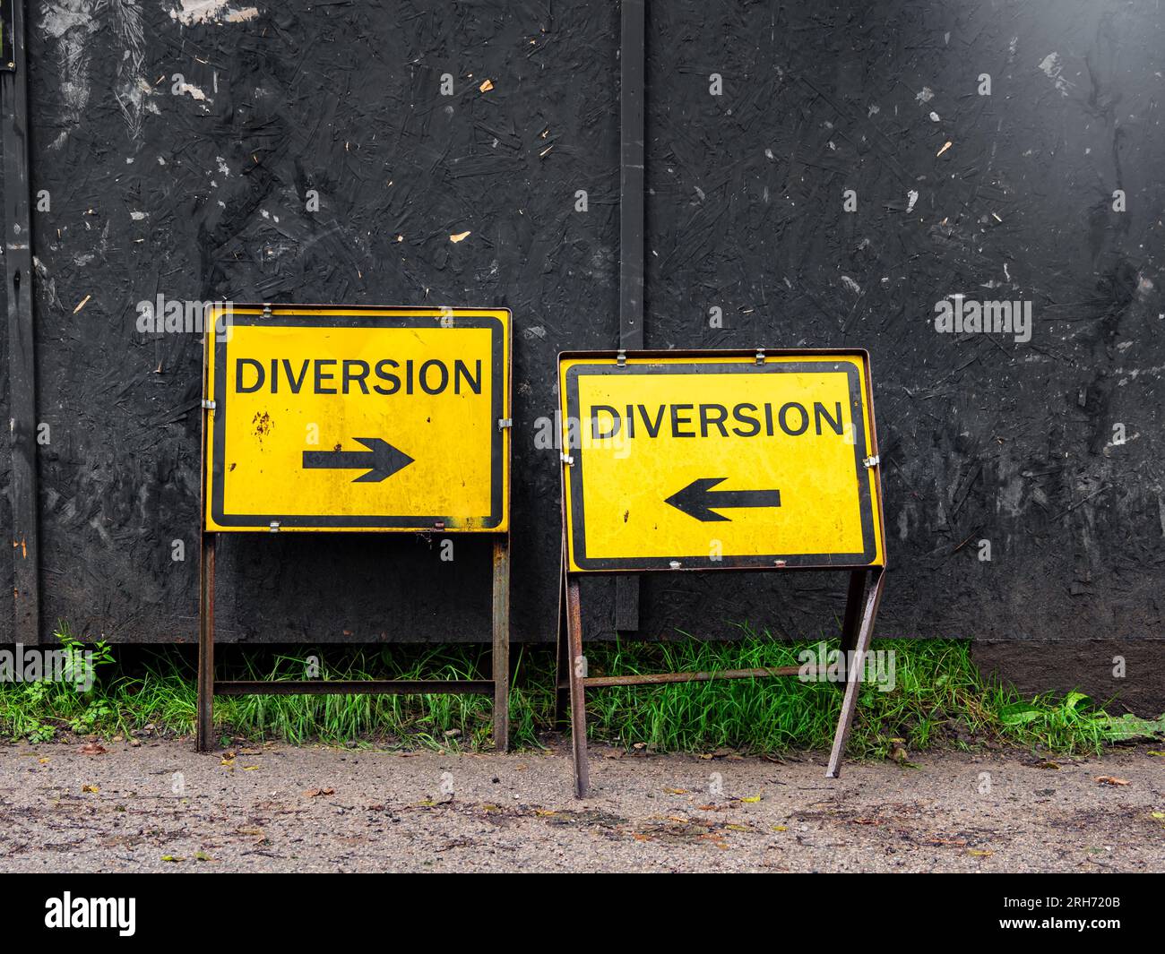 a pair of yellow traffic diversion signs with direction pointing arrows ...