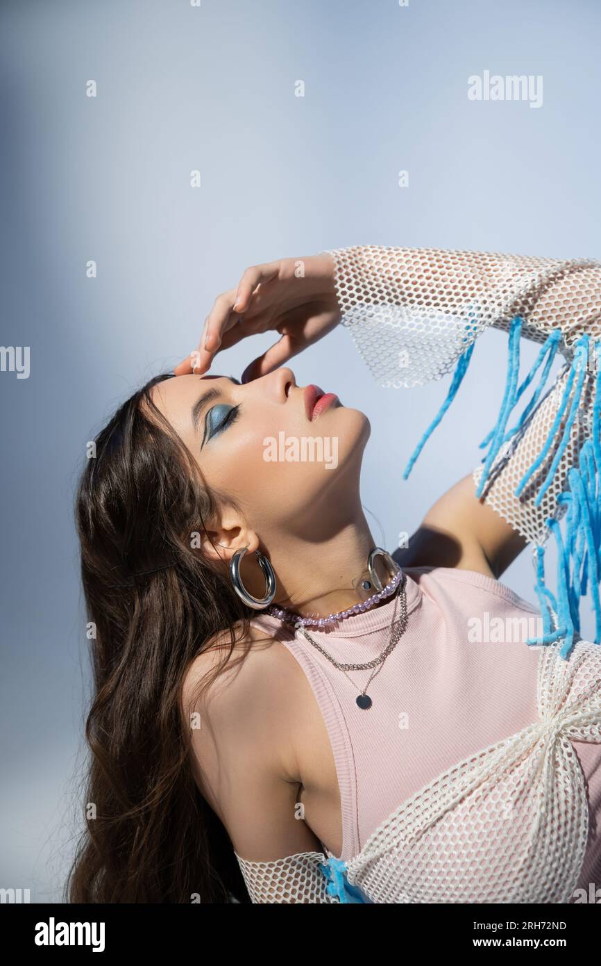 Portrait of young asian model with bold makeup posing in mesh top on ...