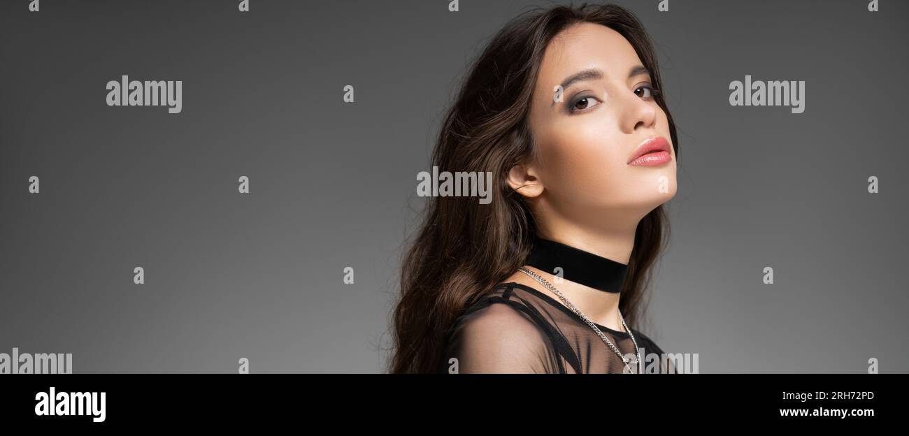 Trendy young asian model in mesh top and silver chains looking at ...