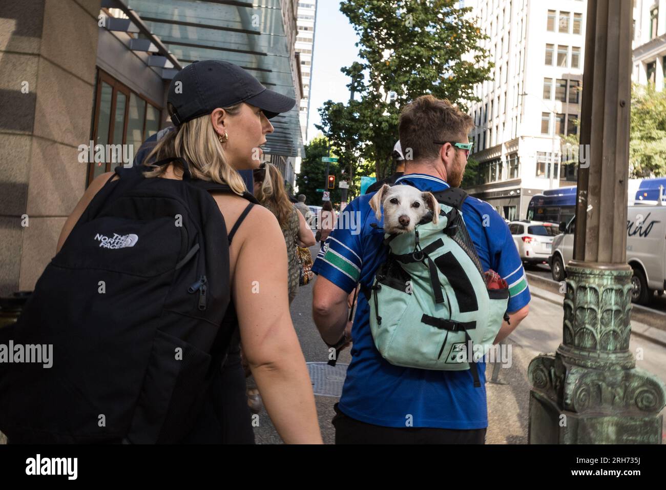 Seattle, USA. 8 Aug, 2023. A couple with a dog in a backpack in ...