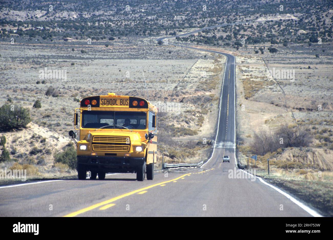 Scenic landscape with winding road and yellow school bus in Nevada, USA ...
