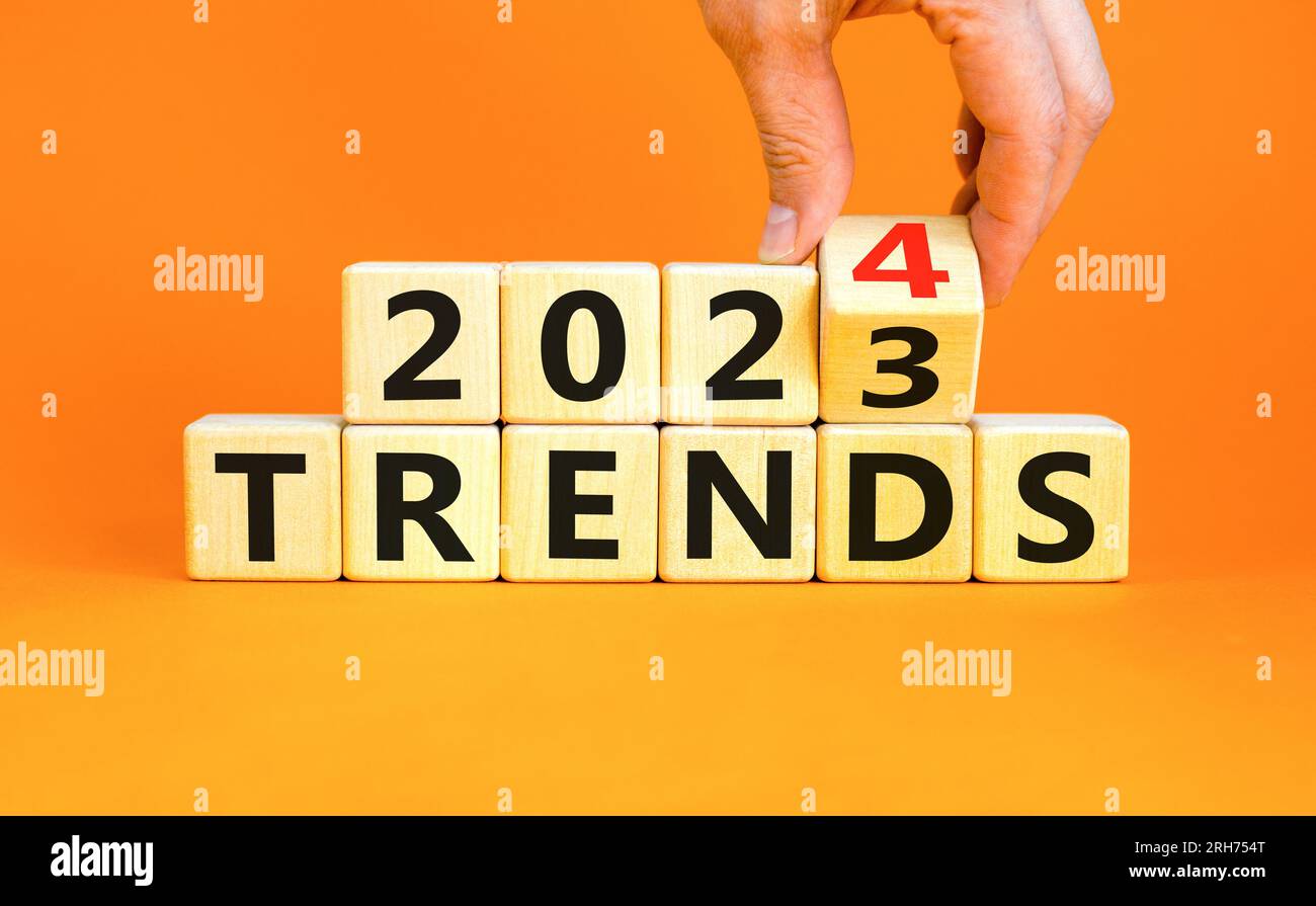 2024 trends new year symbol. Businessman turns a wooden cube and changes words Trends 2023 to ...