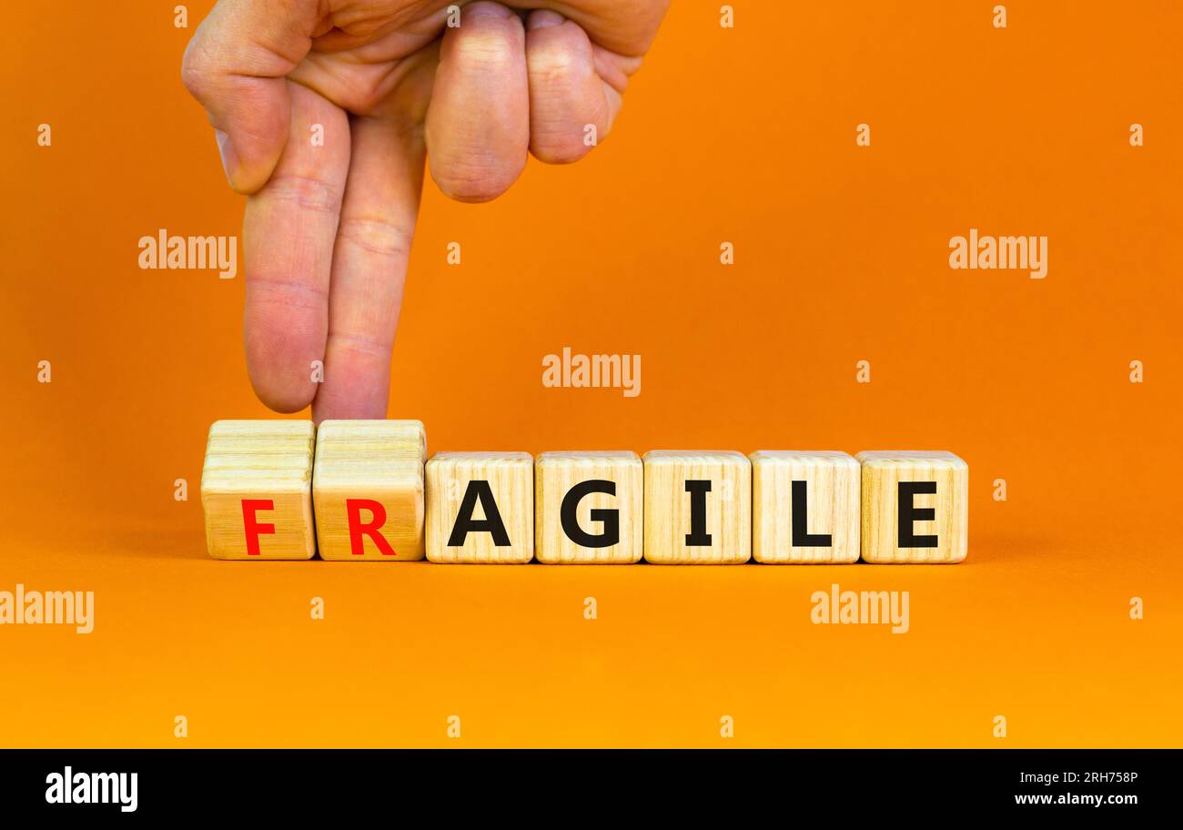 Agile or fragile symbol. Concept words Agile and Fragile on wooden cubes. Beautiful orange table ...