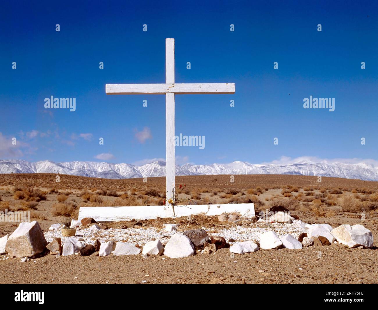Old abandoned nameless grave in the desert with snowed mountains at the ...
