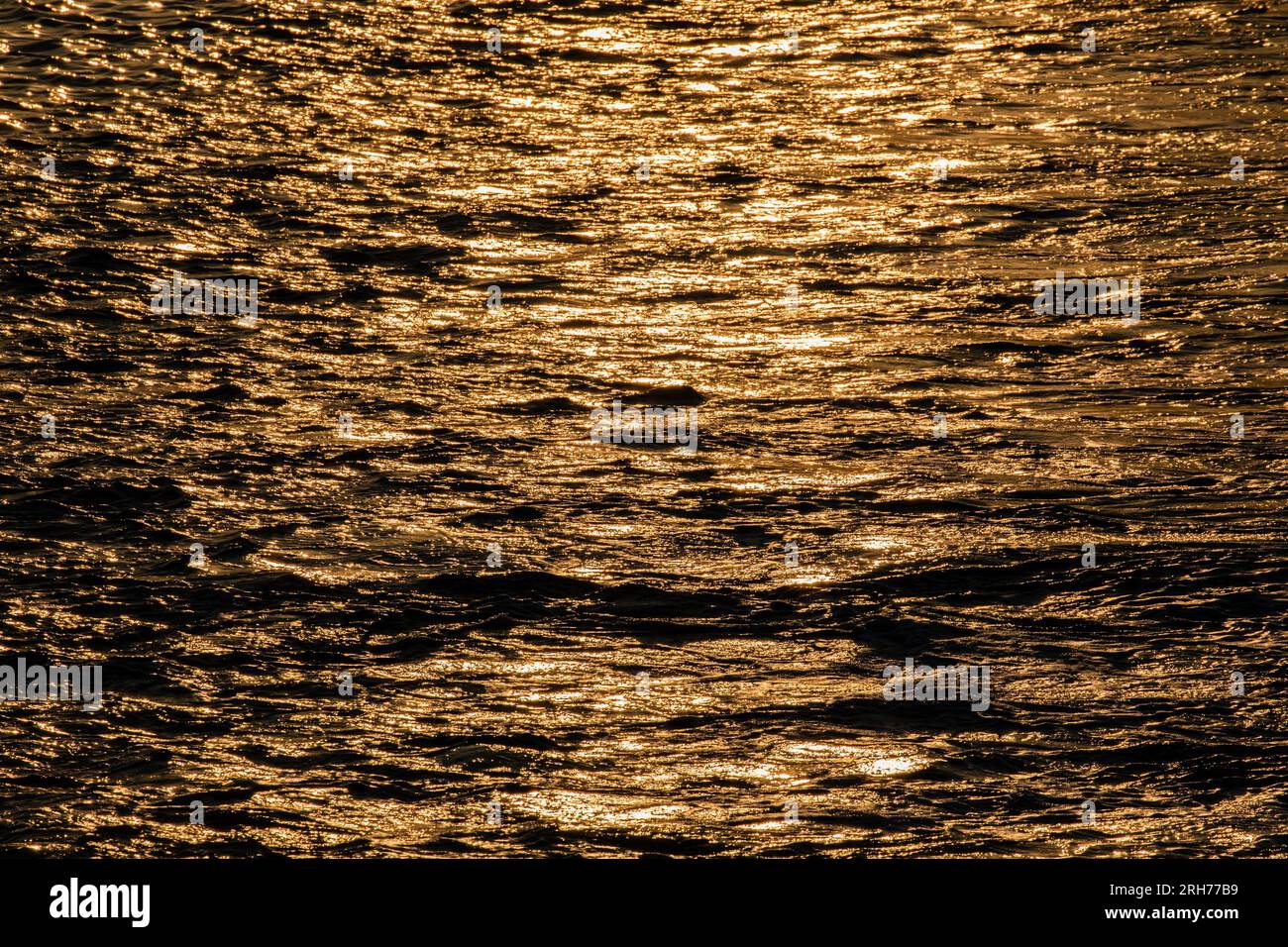 Sun shimmering on the ocean waves at sunset creating a beautiful ...