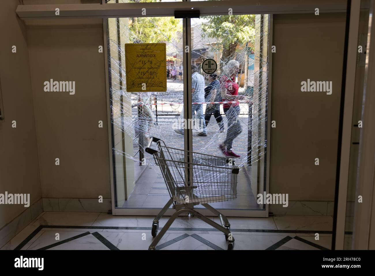 Broken glass of the front door of the supermarket. Modern fashionable ...