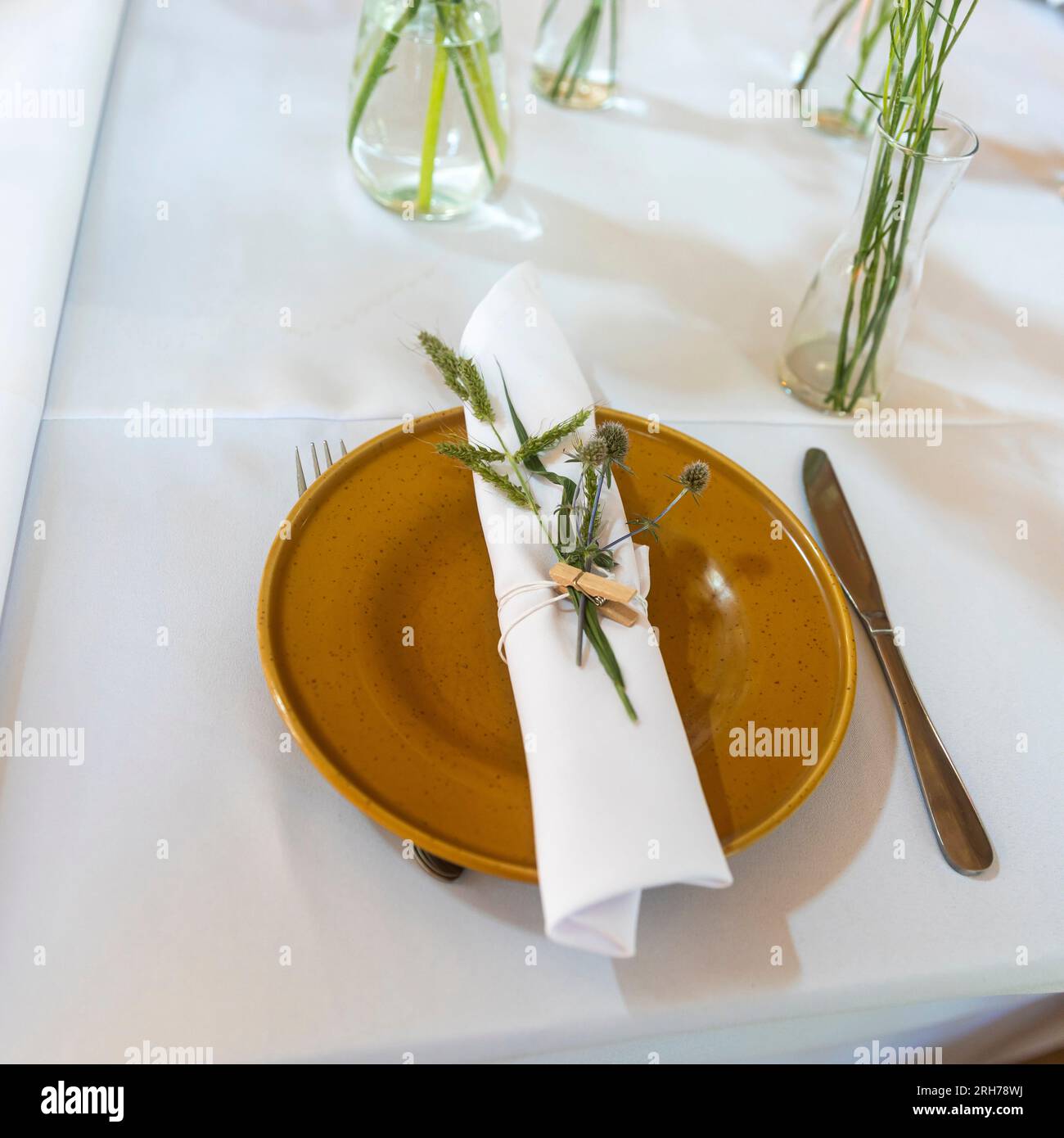 Linen napkin folded into a tube, pinned with a clothespin and decorated ...