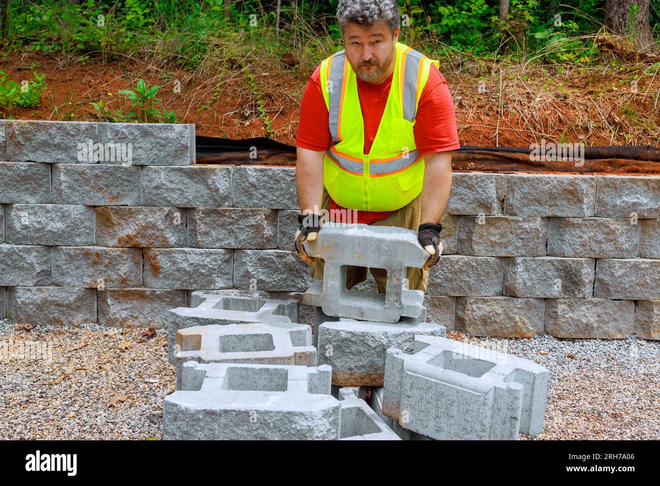 In construction plase worker lifts concrete blocks and positions them ...