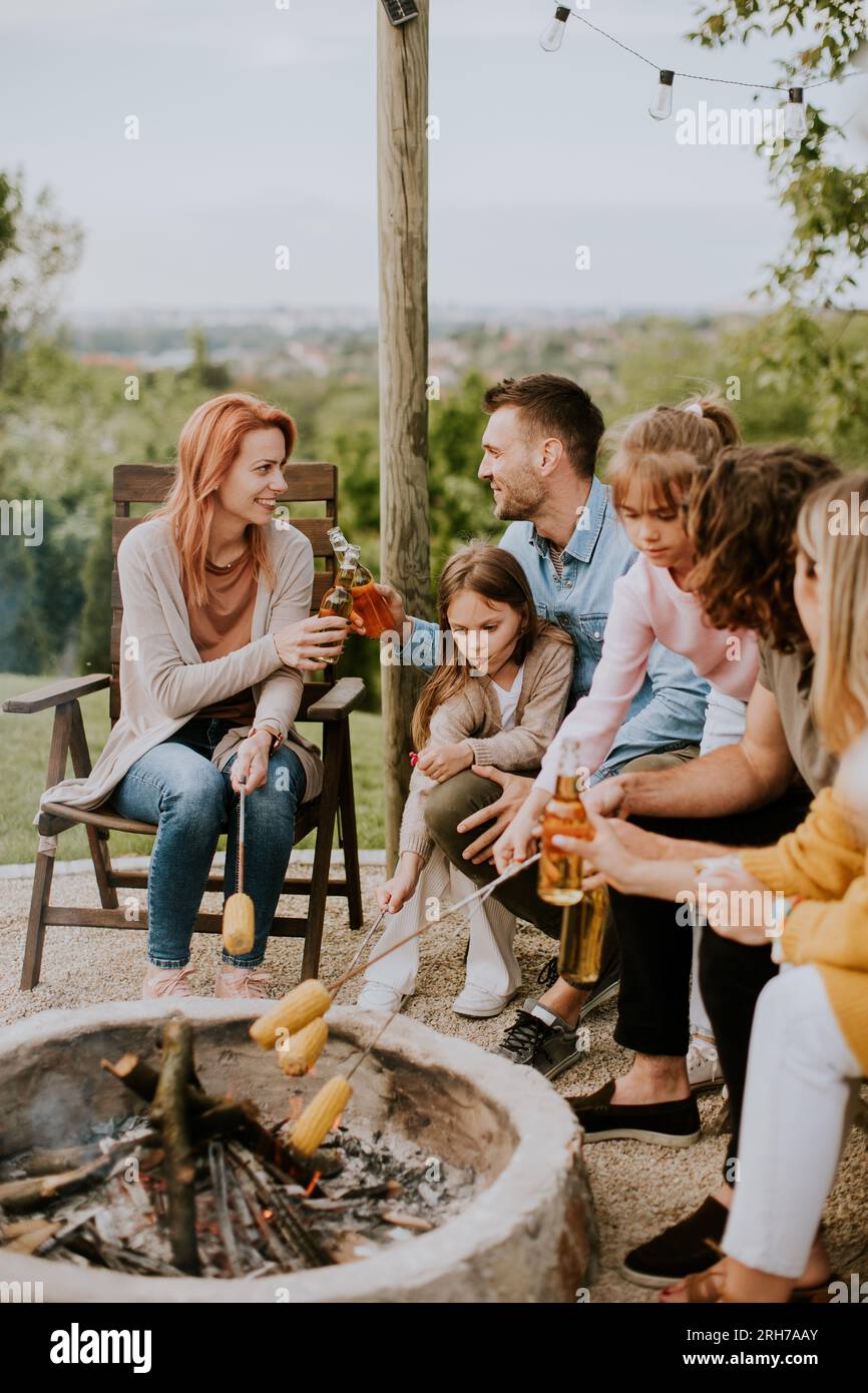 Group of friends having good time and baking corns in the house ...