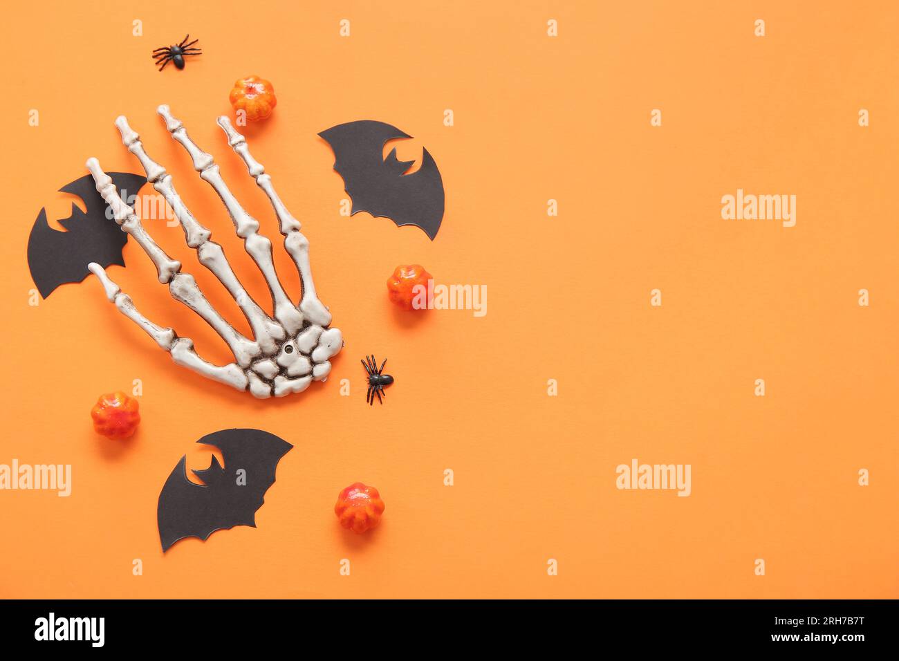 Composition with pumpkins, skeleton hand, paper bats and spiders on ...