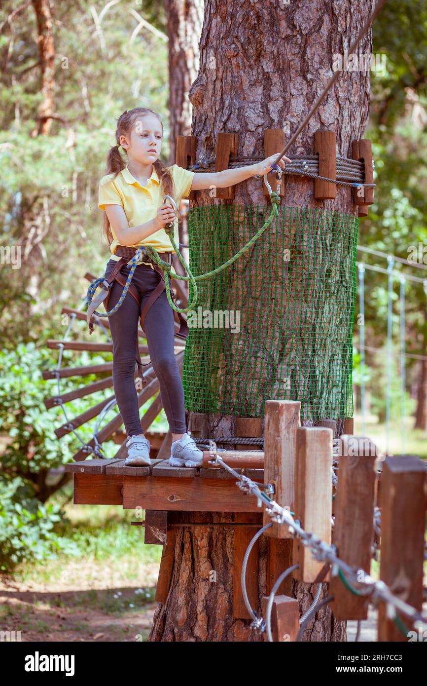 Child in a forest adventure park made of ropes. Children's outdoor ...