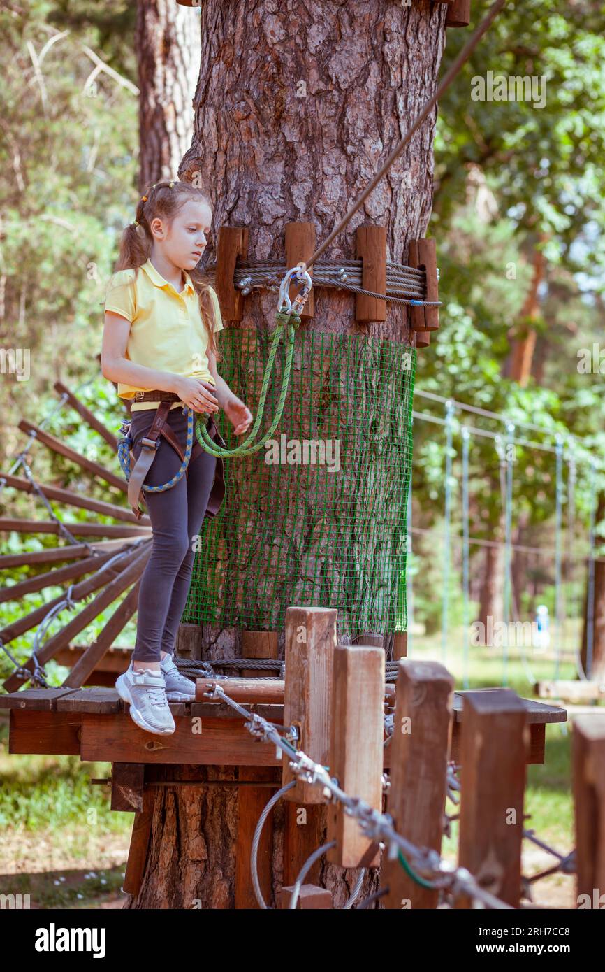 Child in a forest adventure park made of ropes. Children's outdoor ...