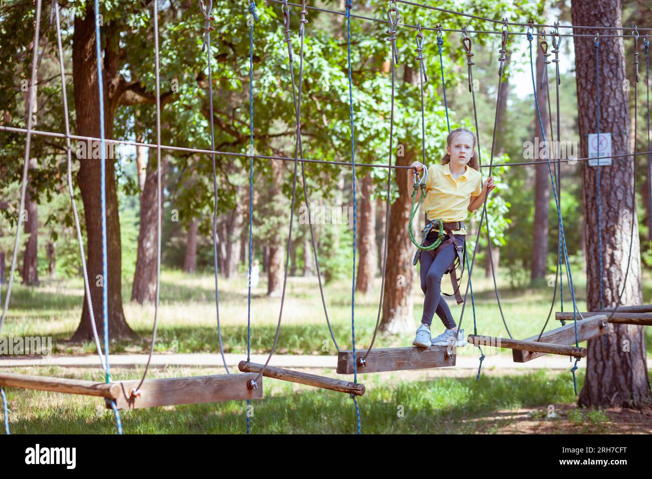 Child in a forest adventure park made of ropes. Children's outdoor ...