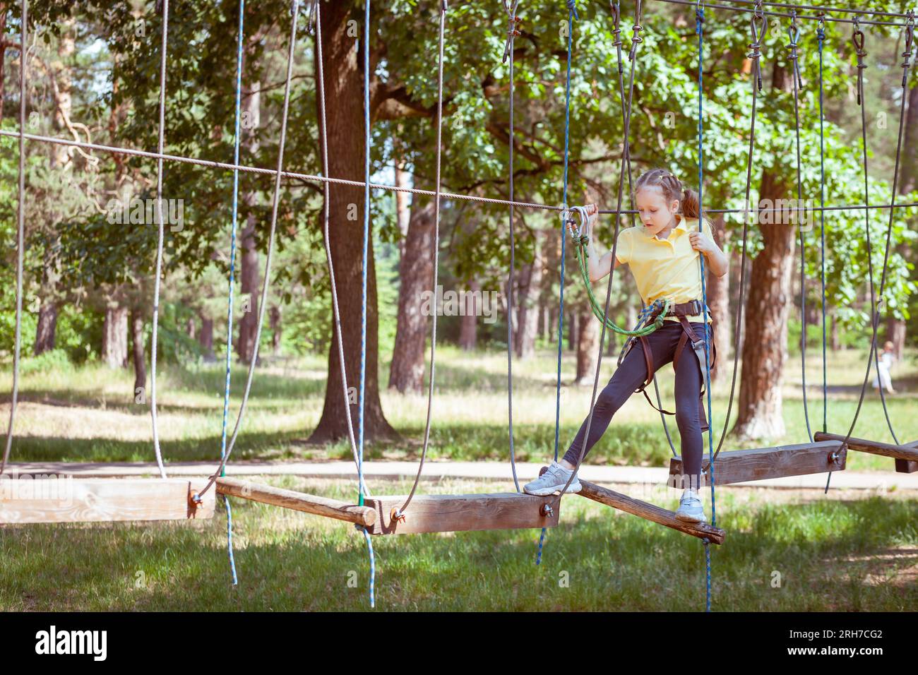 Child in a forest adventure park made of ropes. Children's outdoor ...