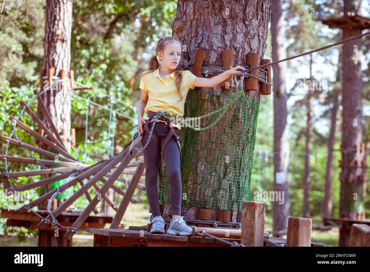 Child in a forest adventure park made of ropes. Children's outdoor ...