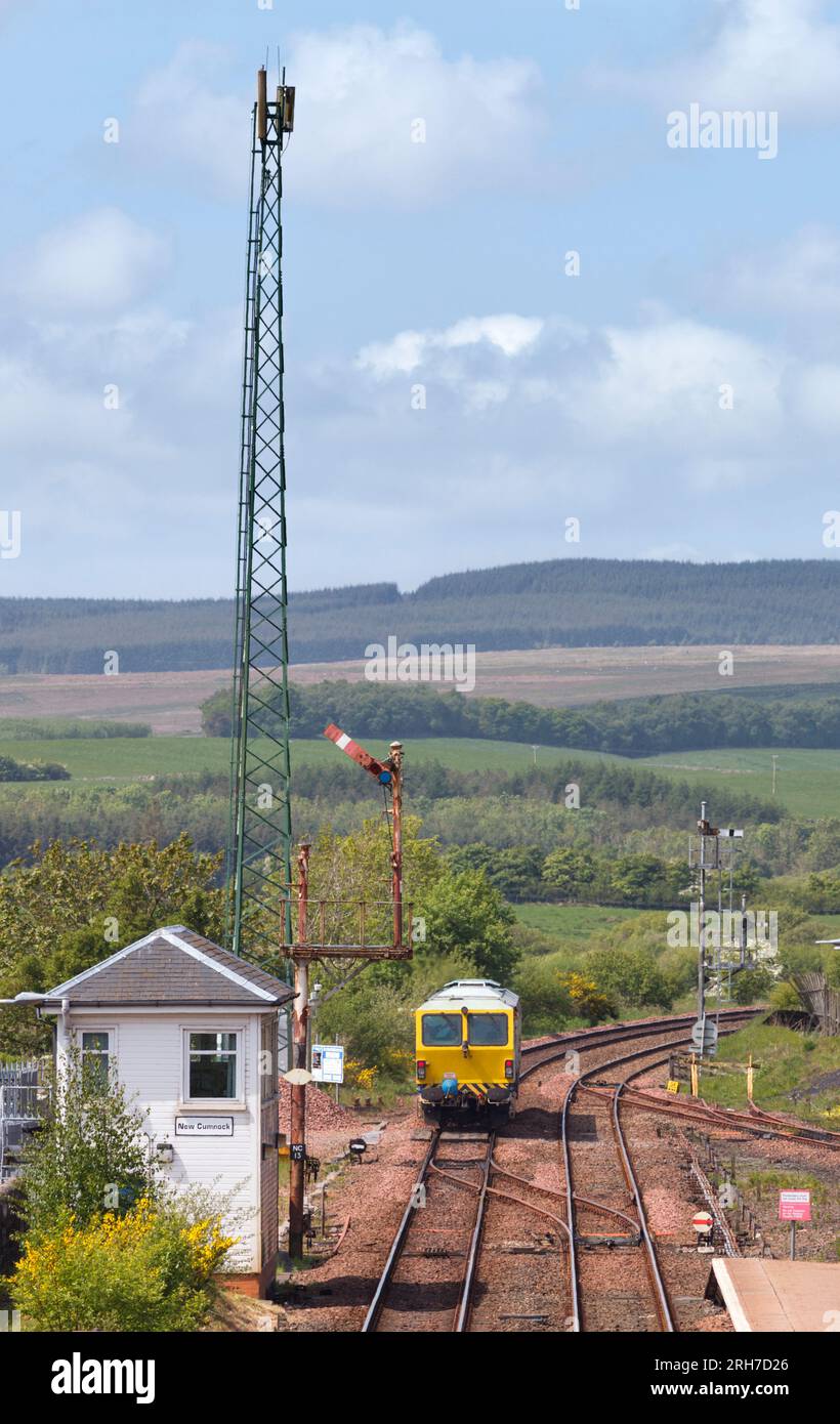 Railway track tamping machine passing the mechanical signal box and ...