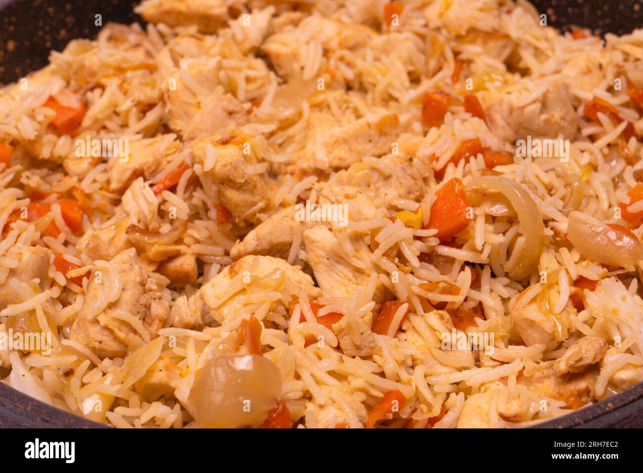 Tasty pilaf with chicken in a frying pan. Isolated on a white ...