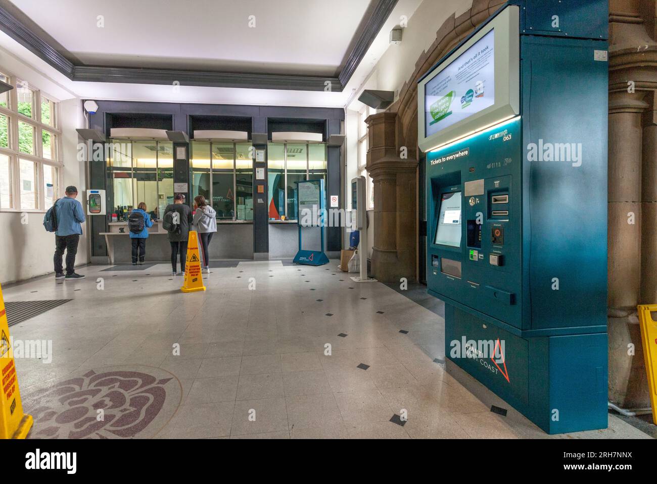 Lancaster railway station ticket office with a passenger buying a ...