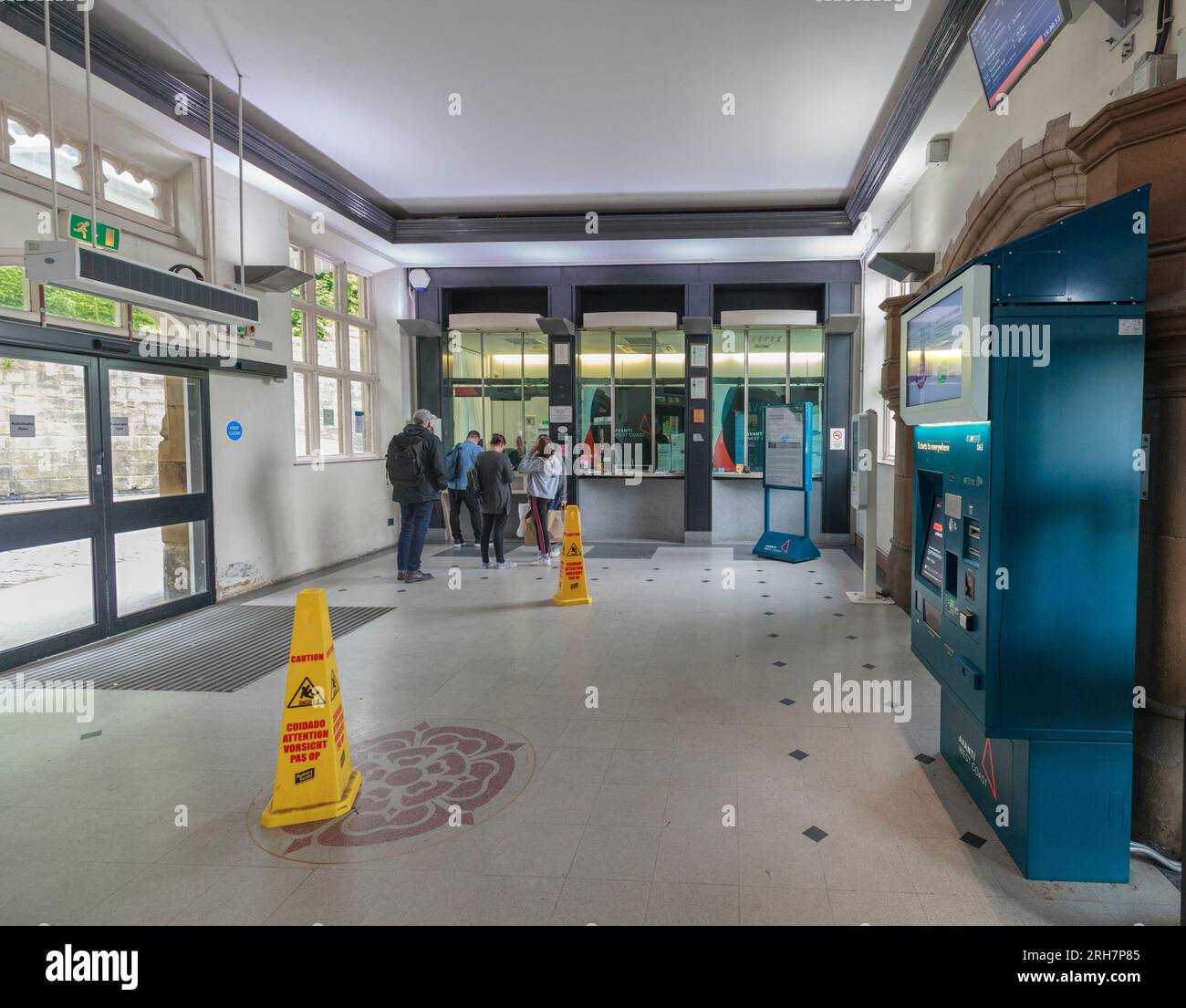 Lancaster railway station ticket office with a passenger buying a ...