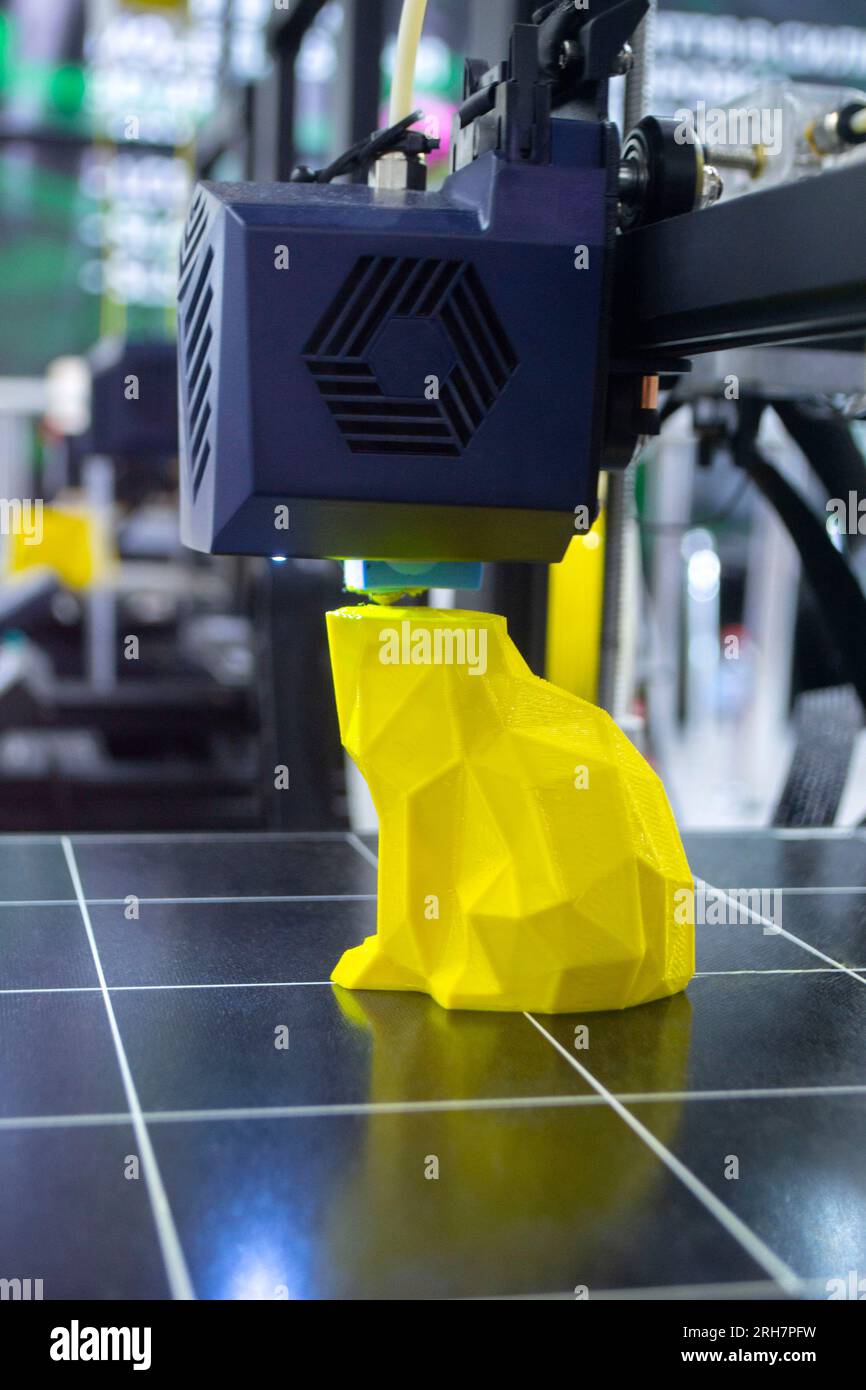 3D printer printing prototype of toy from molten plastic. Process of ...