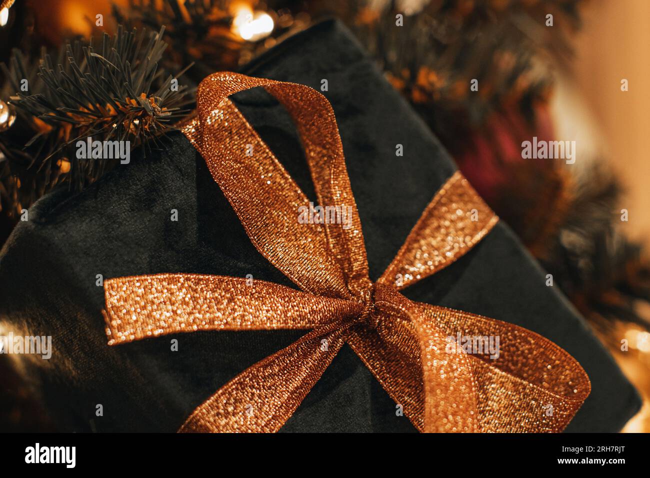Velvet dark green Christmas gift box with a golden shiny ribbon hanging ...