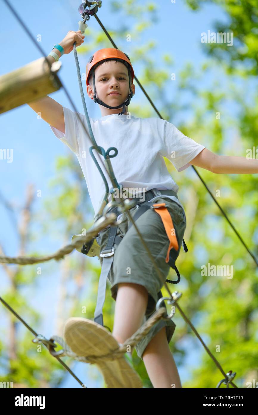 Portrait of teenage boy having fun at outdoor extreme adventure park ...