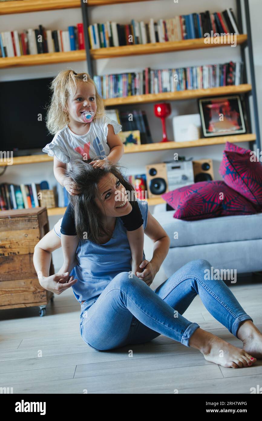 Mother And Daughter Energetically Play In The Living Room Hands Feet And Bodies Wrestle