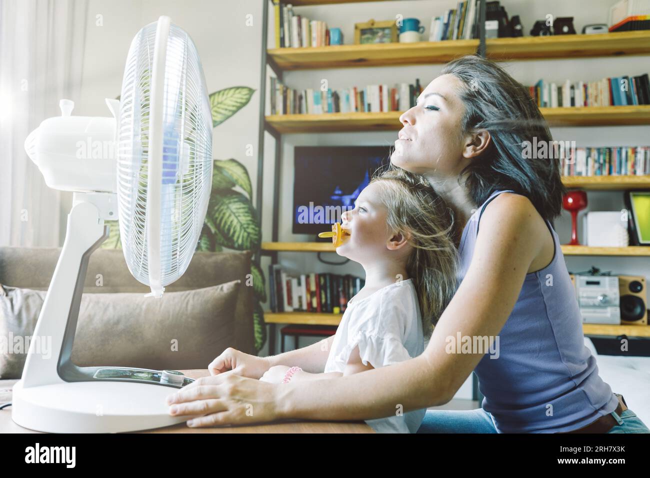 Sweltering heat, but the cool fan becomes a stage for mother and daughter's playful dances ...