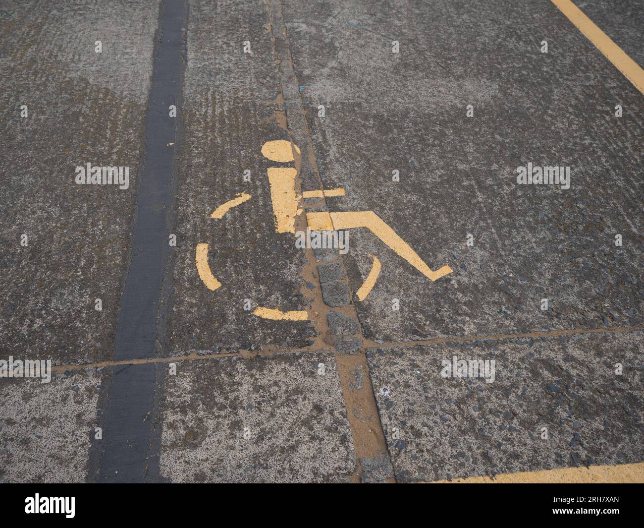 A wheelchair symbol is painted on the street. It marks a parking lot ...