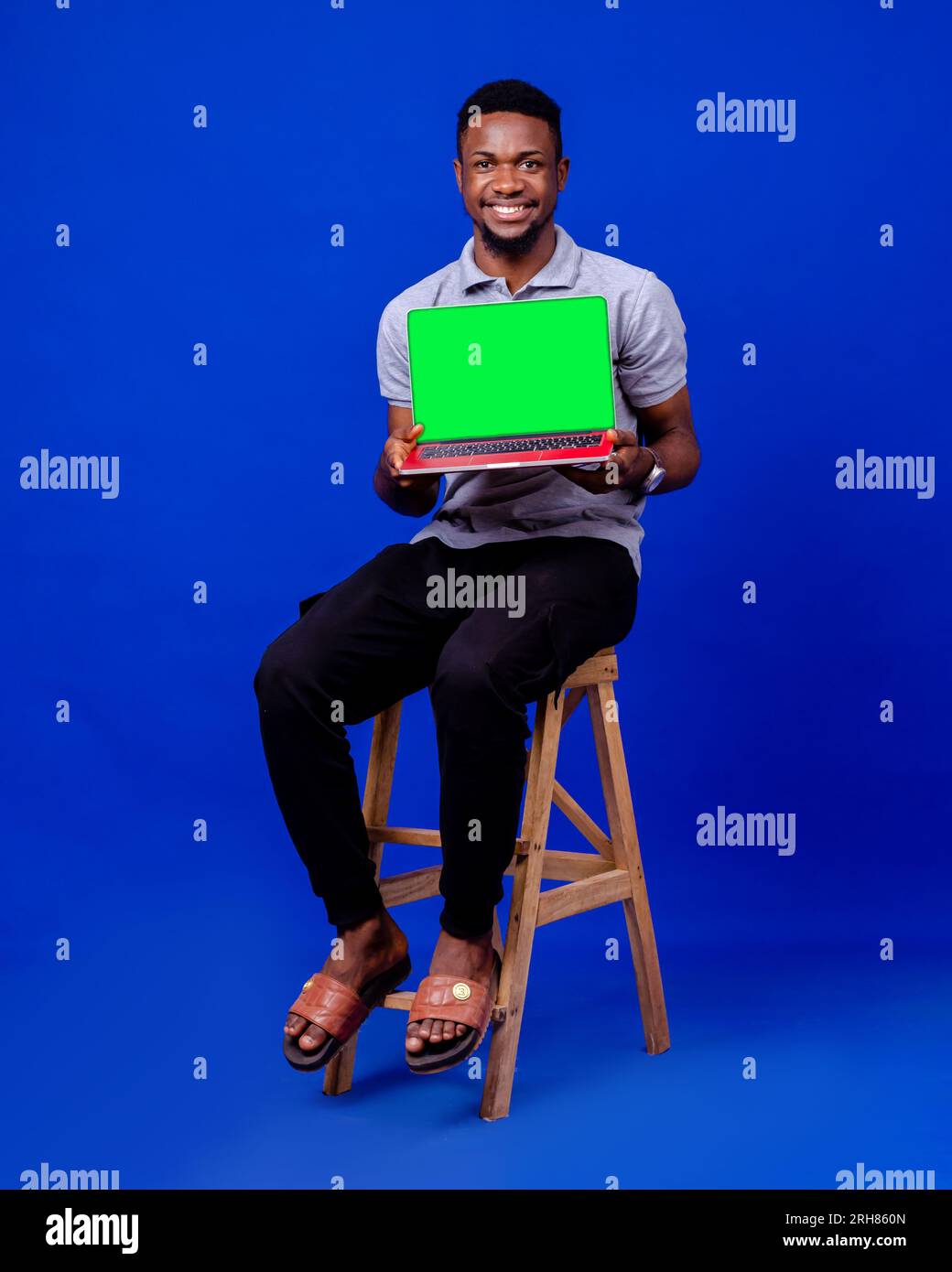 full length of an african handsome african man holding his laptop Stock ...
