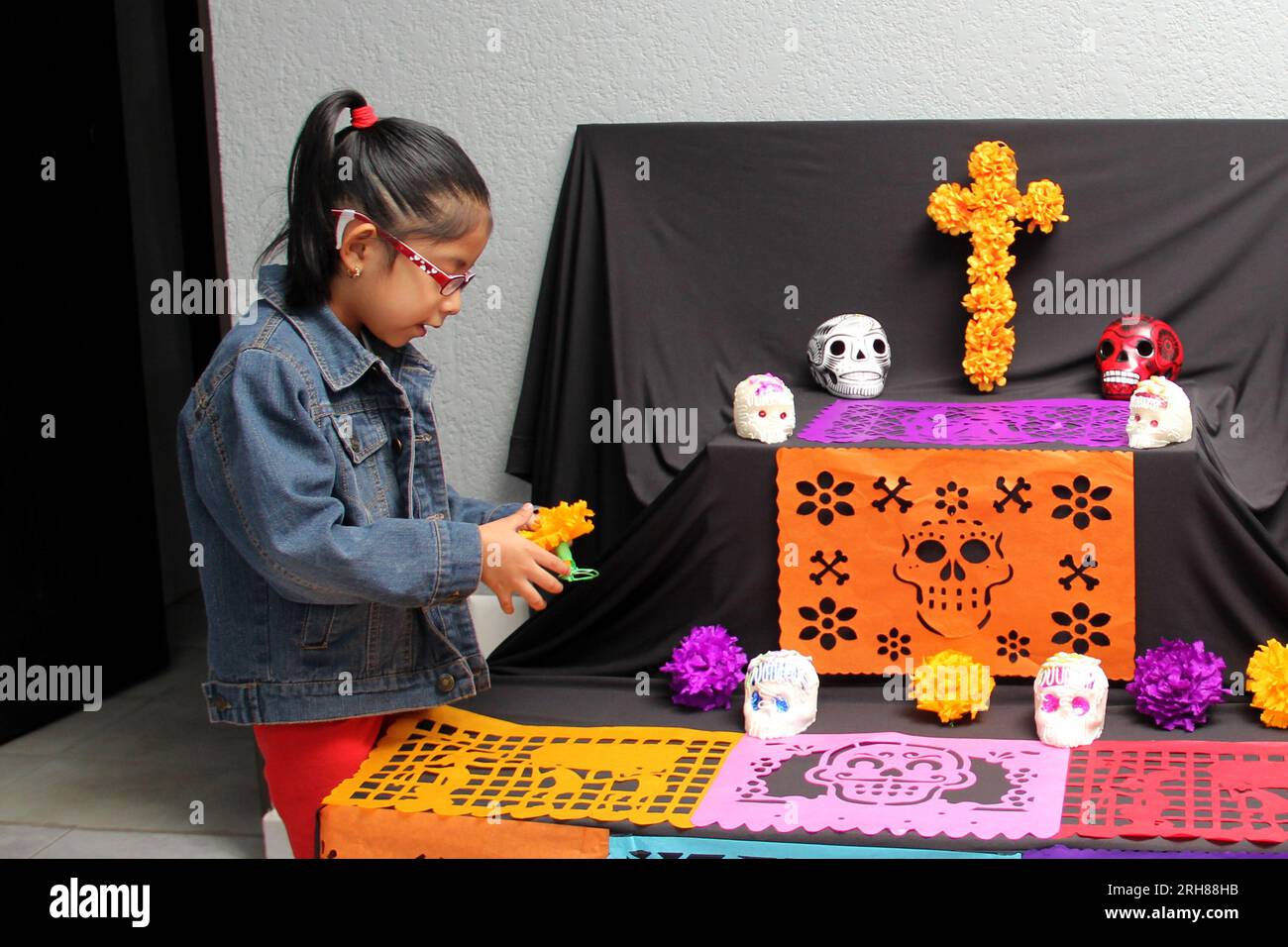 Mexican child girl put the altar and offering of the Day of the Dead in ...
