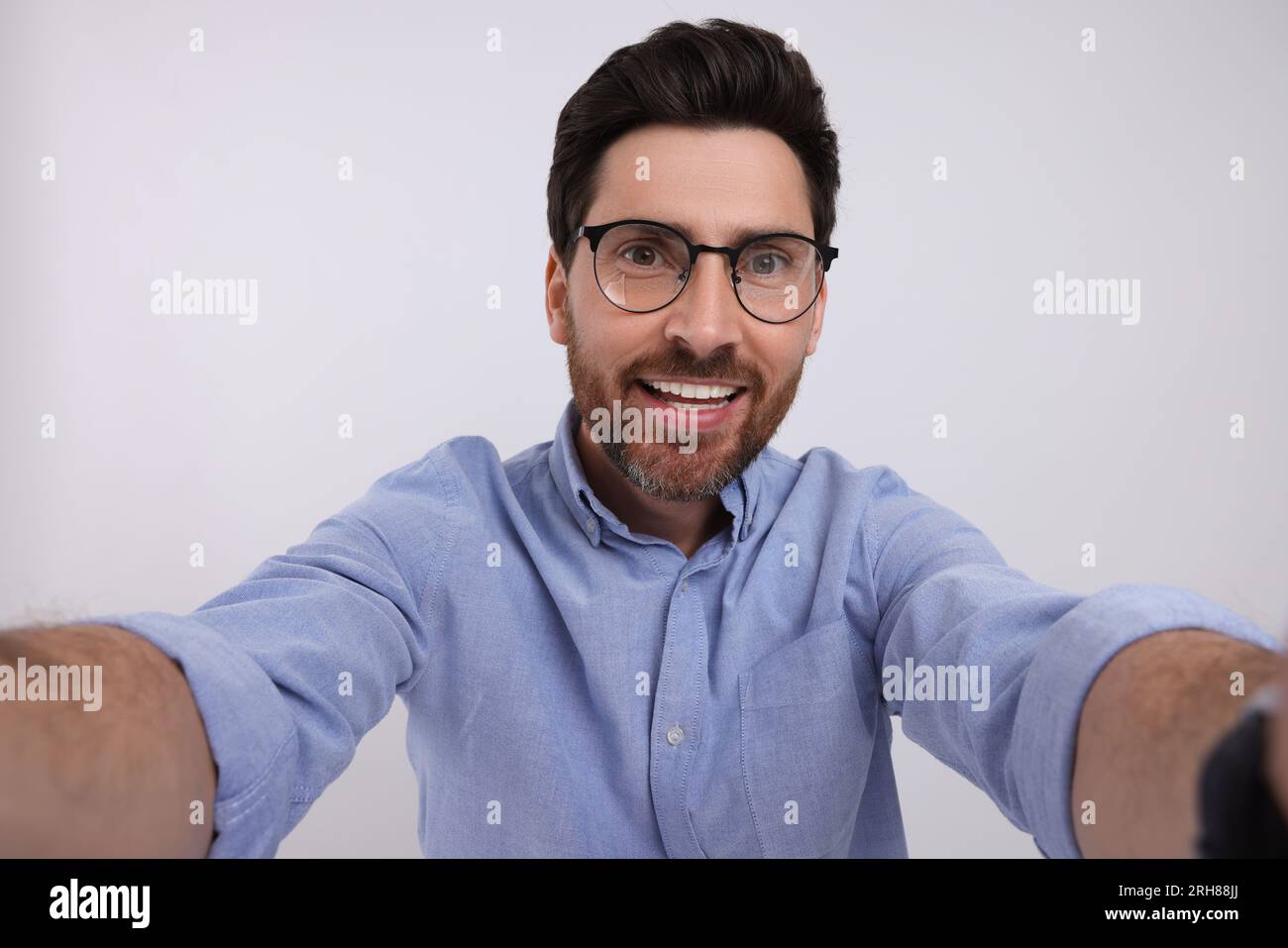 Smiling man taking selfie on white background Stock Photo - Alamy
