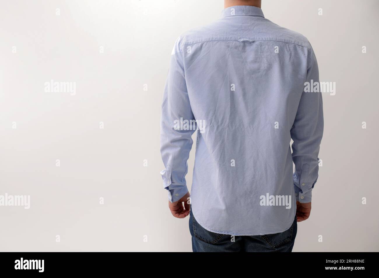 Man wearing rumpled shirt on white background, back view Stock Photo ...