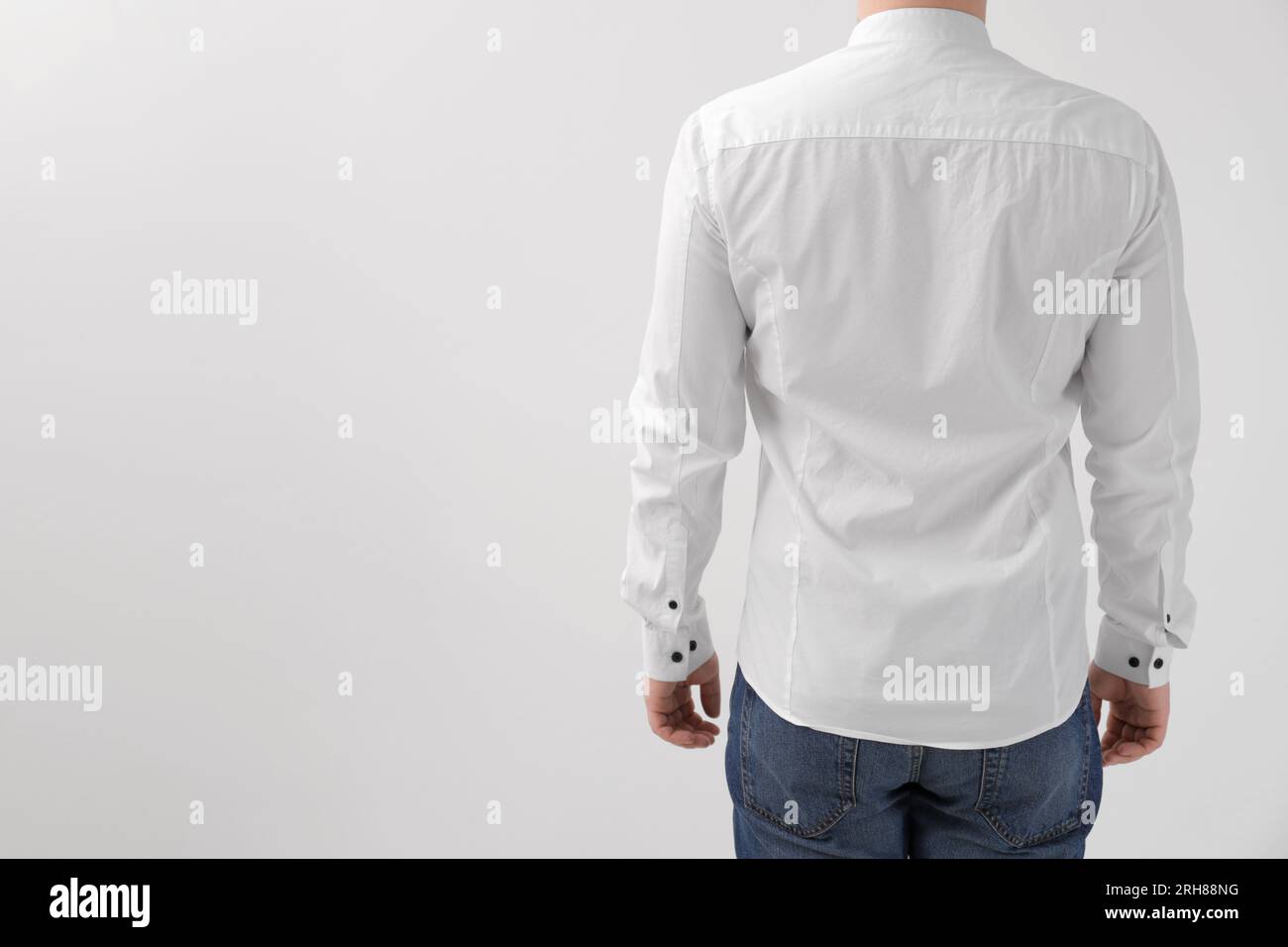 Man wearing rumpled shirt on white background, back view Stock Photo ...