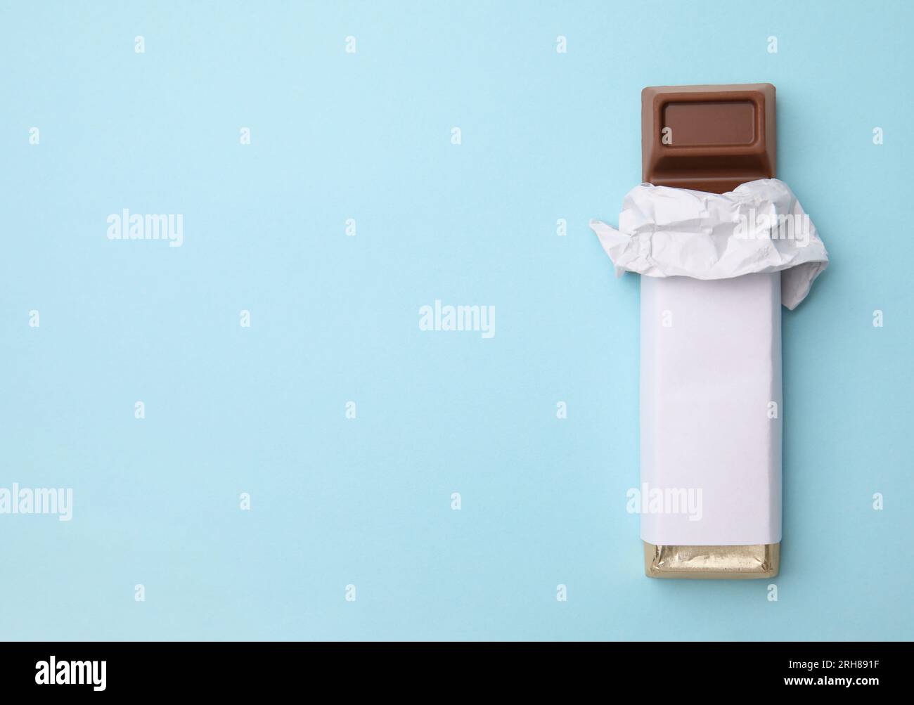 Tasty chocolate bar in package on light blue background, top view ...