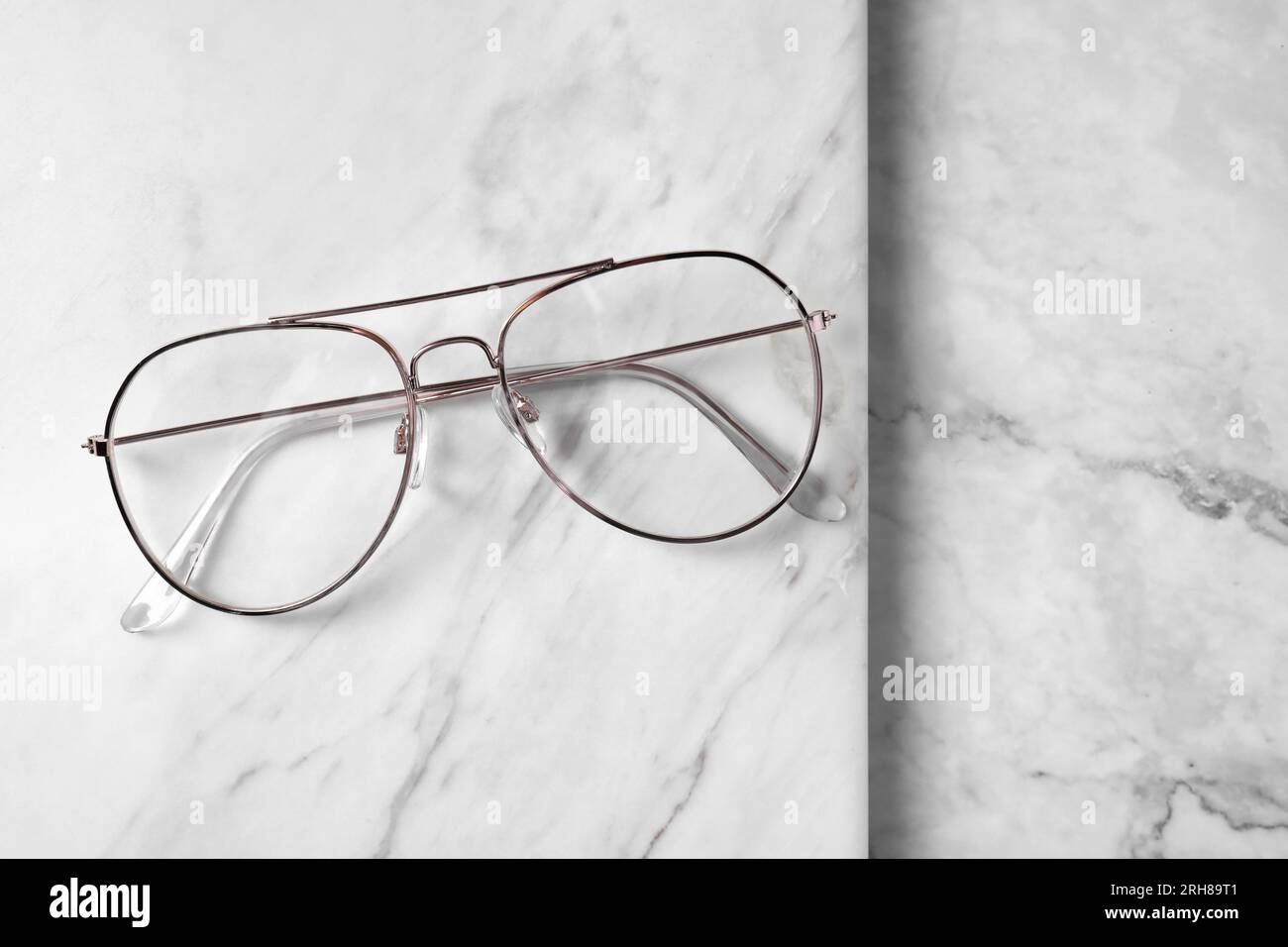 Glasses in stylish frame on white marble background, top view. Space ...