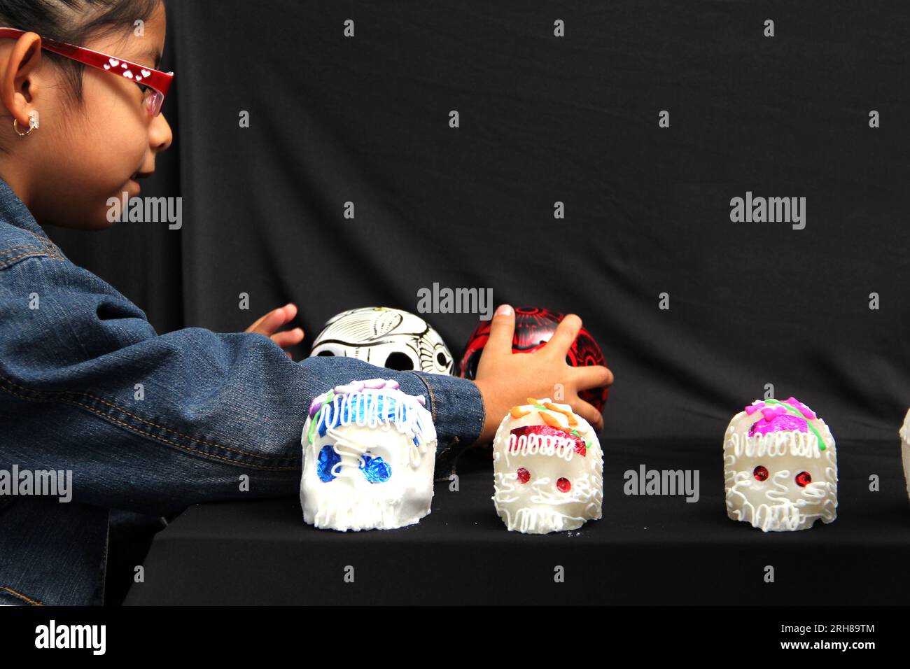 Mexican child girl put the altar and offering of the Day of the Dead in ...