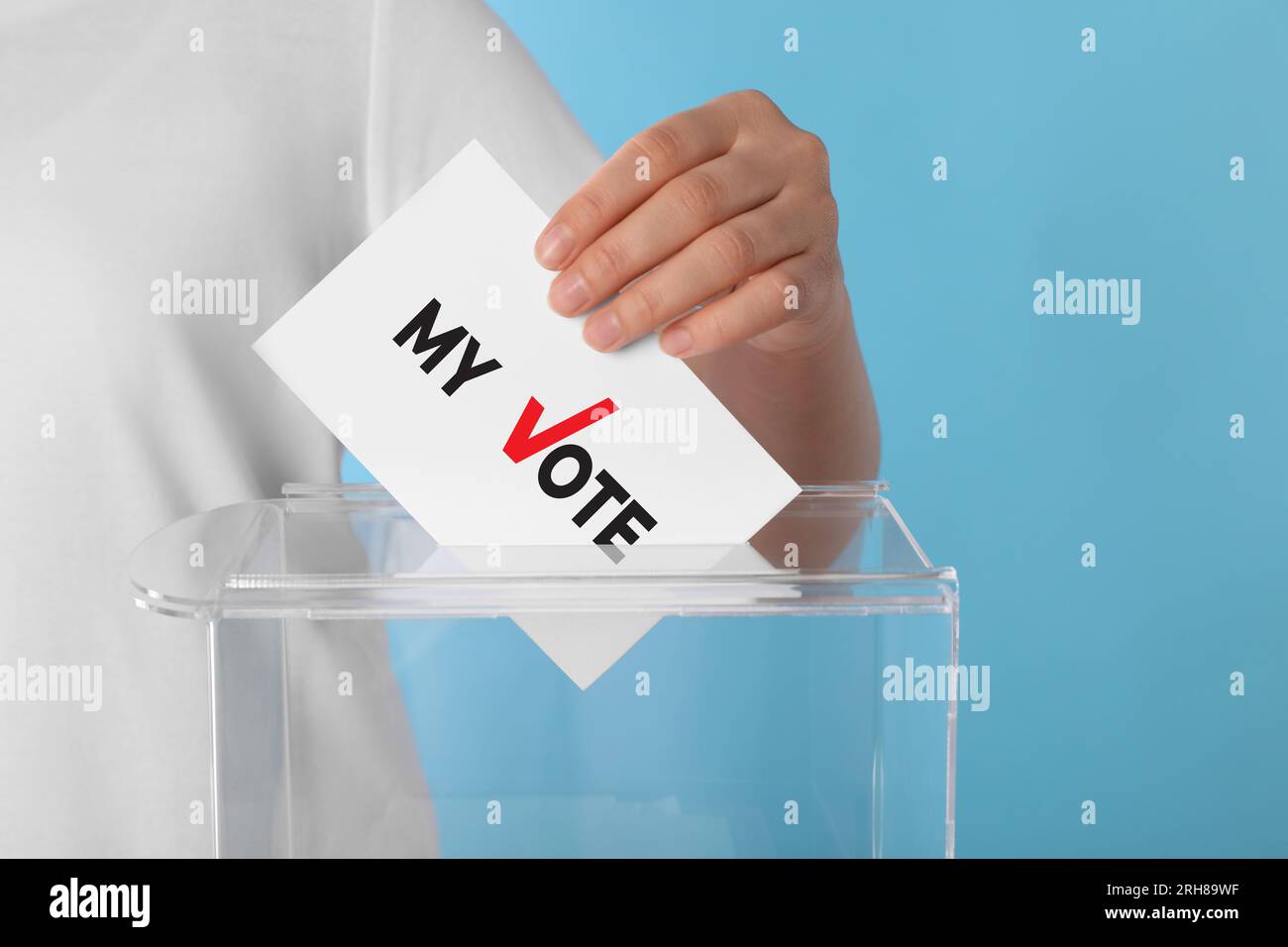 Woman putting paper with text My Vote and tick into ballot box on light ...