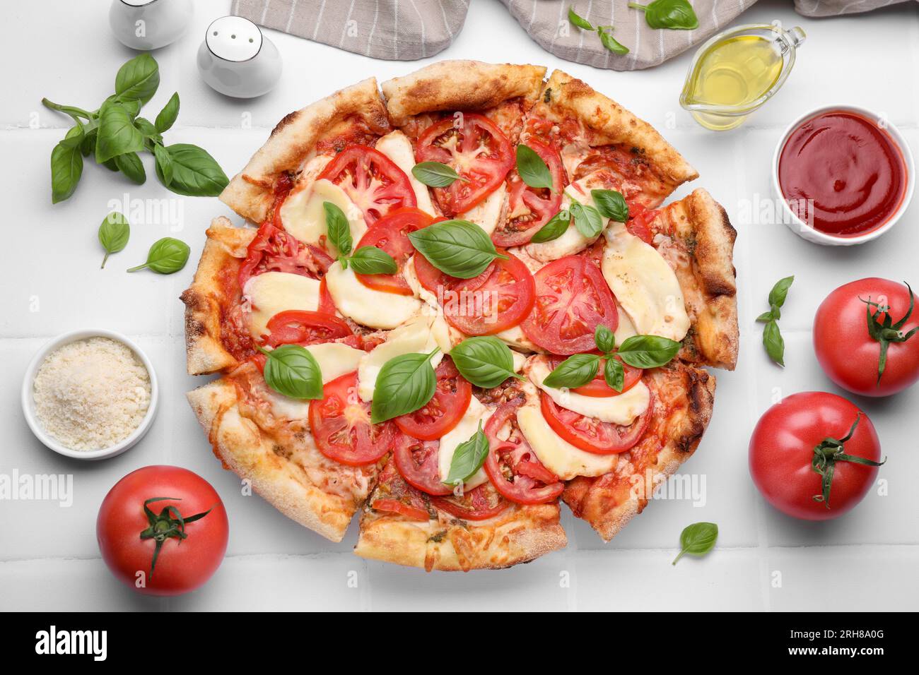 Delicious Caprese pizza and ingredients on white tiled table, flat lay ...