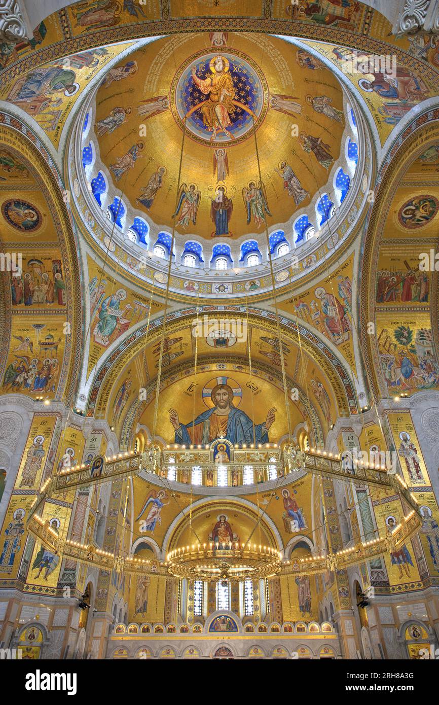 The ornately decorated ceiling with golden frescoes and wheel chandelier at the Church of Saint ...