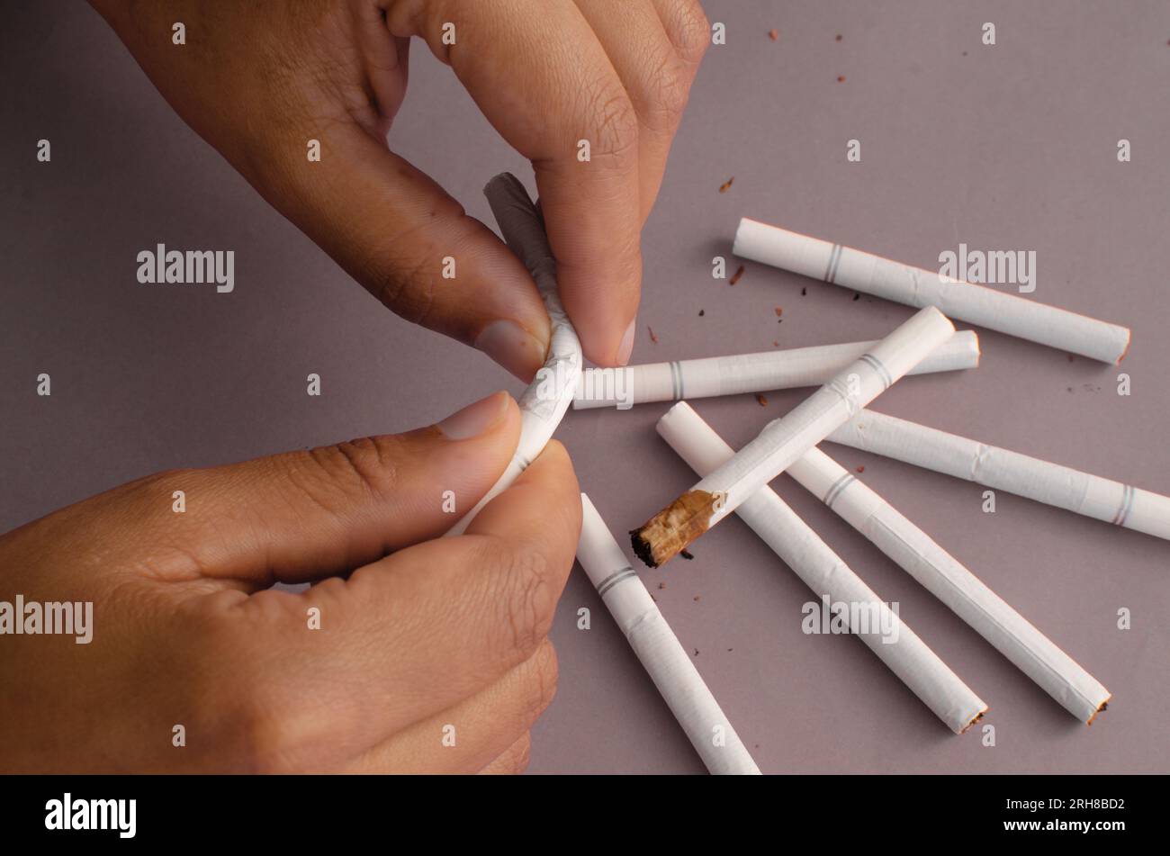 Close-up of a hand holding a cigarette with visible tobacco ...