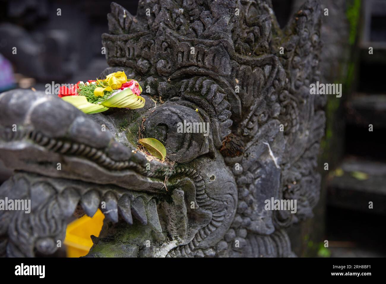 Indonesian Deity Carved Statue with daily offerings Stock Photo - Alamy