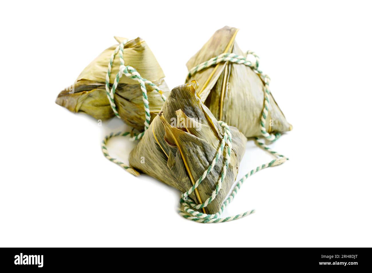 Three Chinese steamed sticky rice dumplings, zongzi or bakcang, wrapped ...